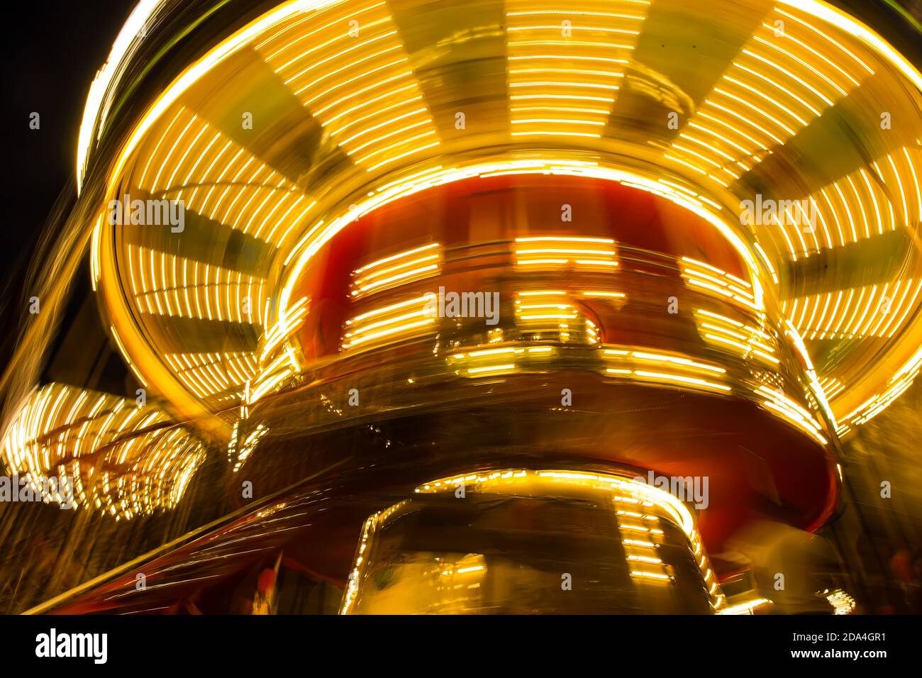 rotating lighted children's merry-go-round at night. Blurred motion ...
