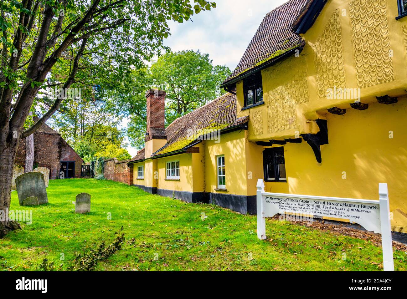 Yellow Tudor style house with wave crest pattern facade next to Church ...