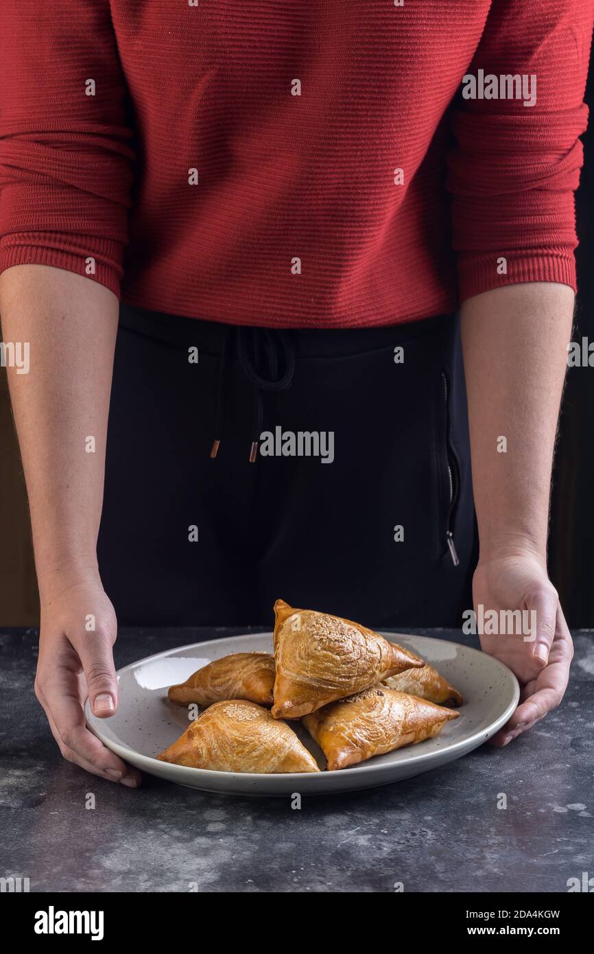 Traditional asian food. Samsa, samosa with meat. Girl is holding a ...