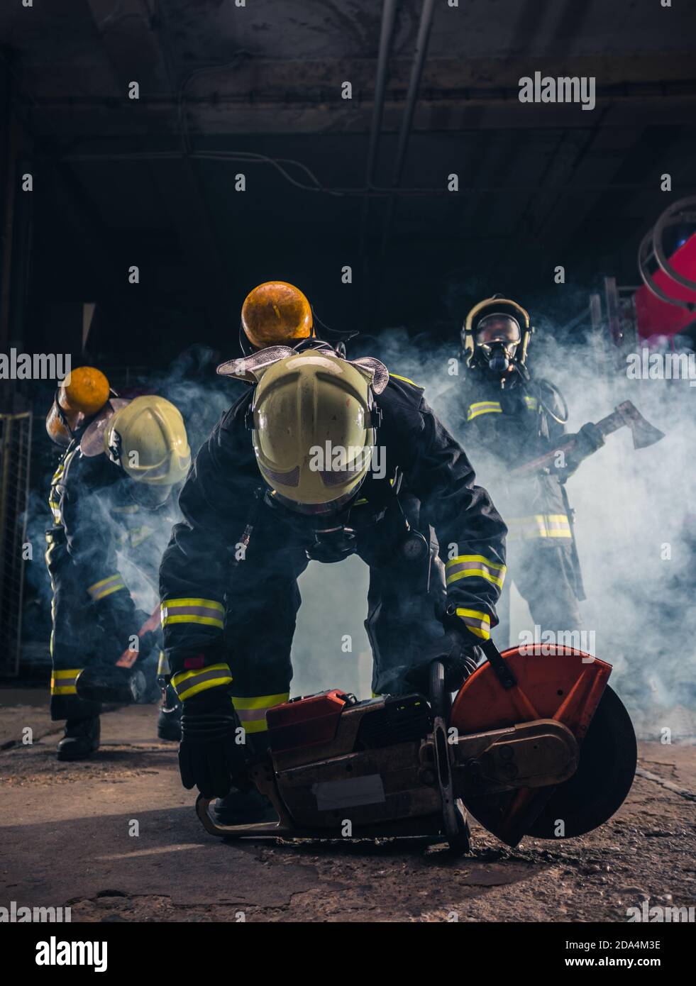 Group of three young fireman posing inside the fire department with ...