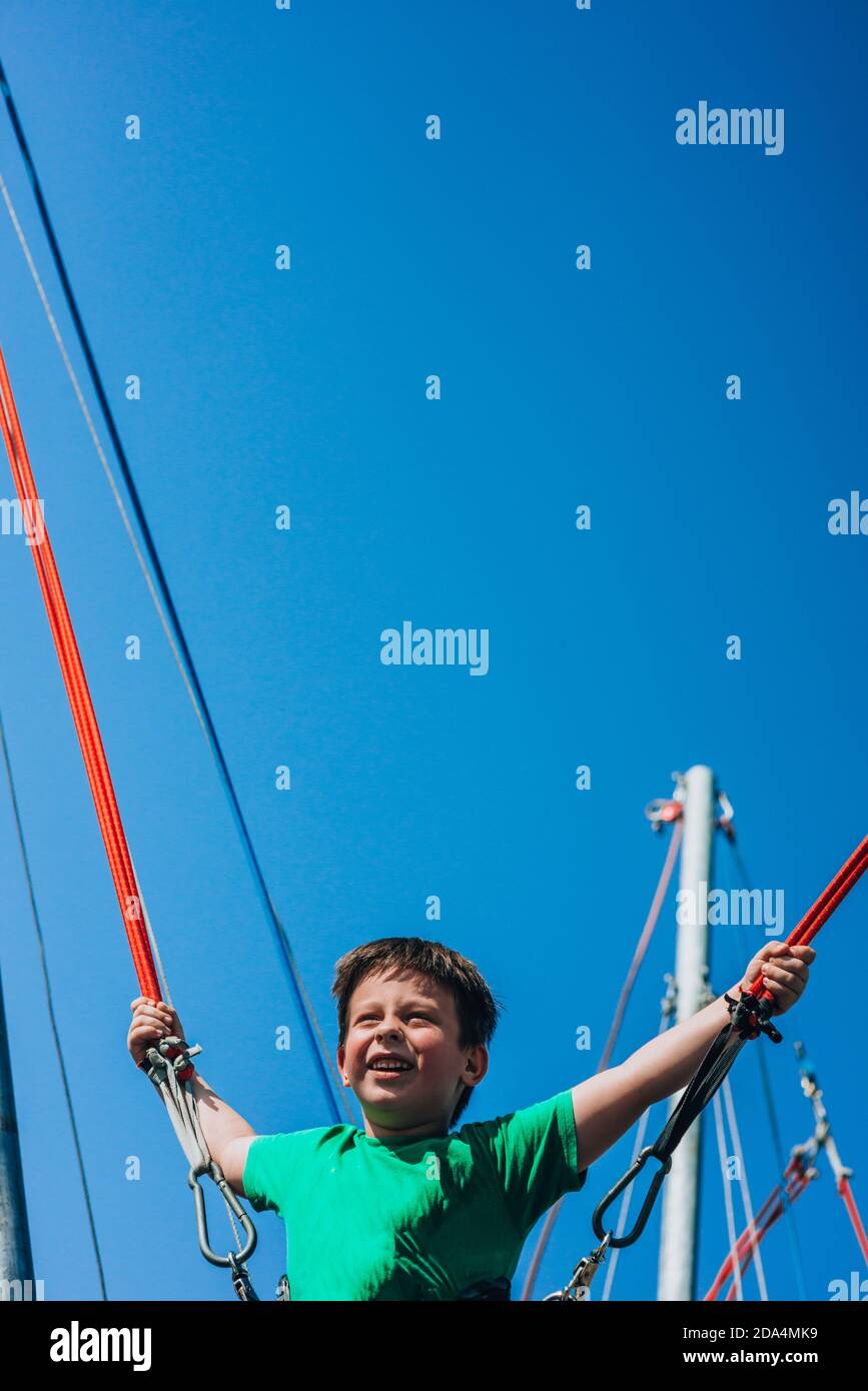 Cute joyful smiling boy playing on the big bungee trampoline Stock ...