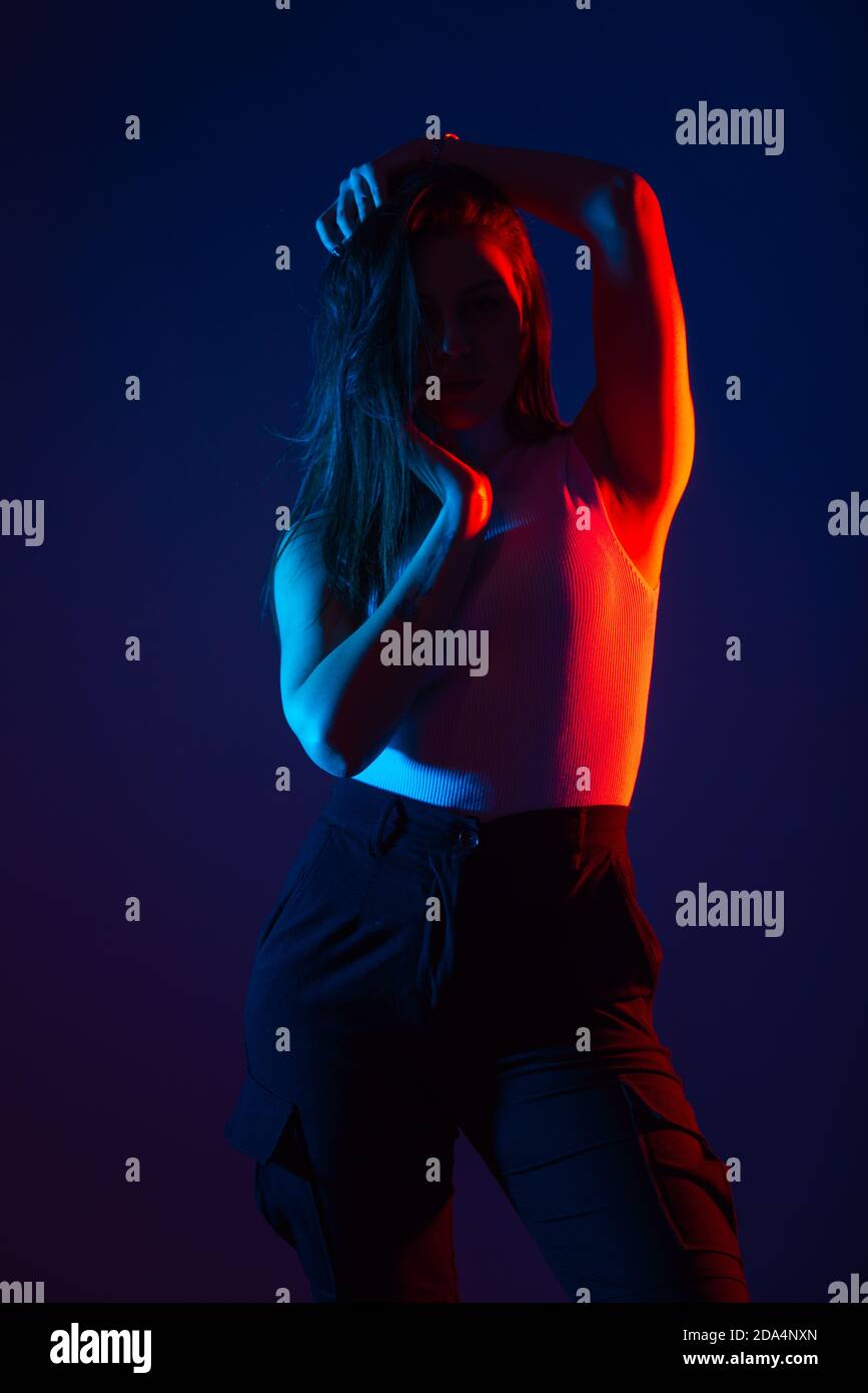 Female model posing in studio with red and blue colors at high contrast ...