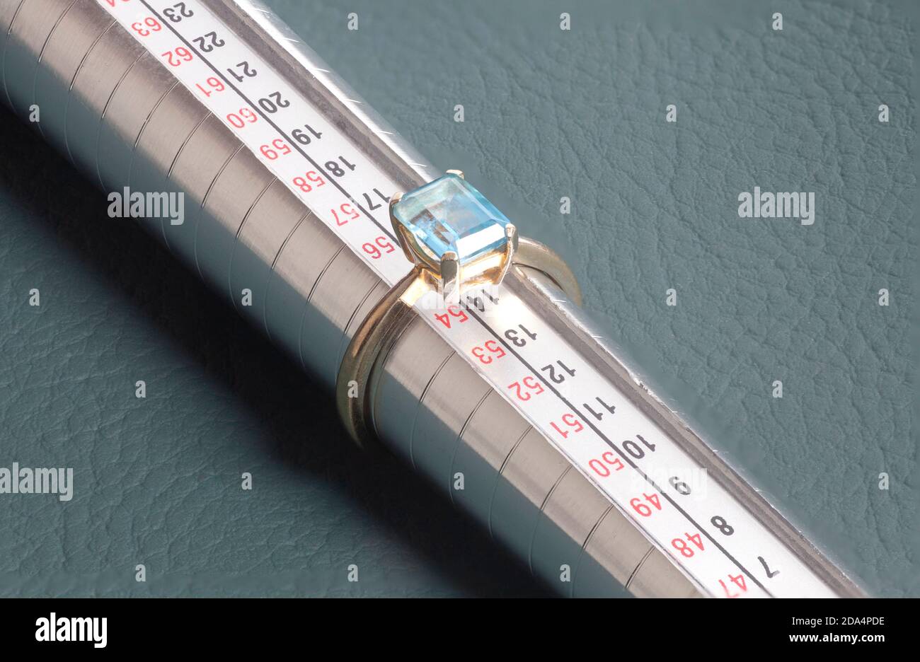 Gold wedding ring with sapphire on a ring sizer gauge Stock Photo - Alamy