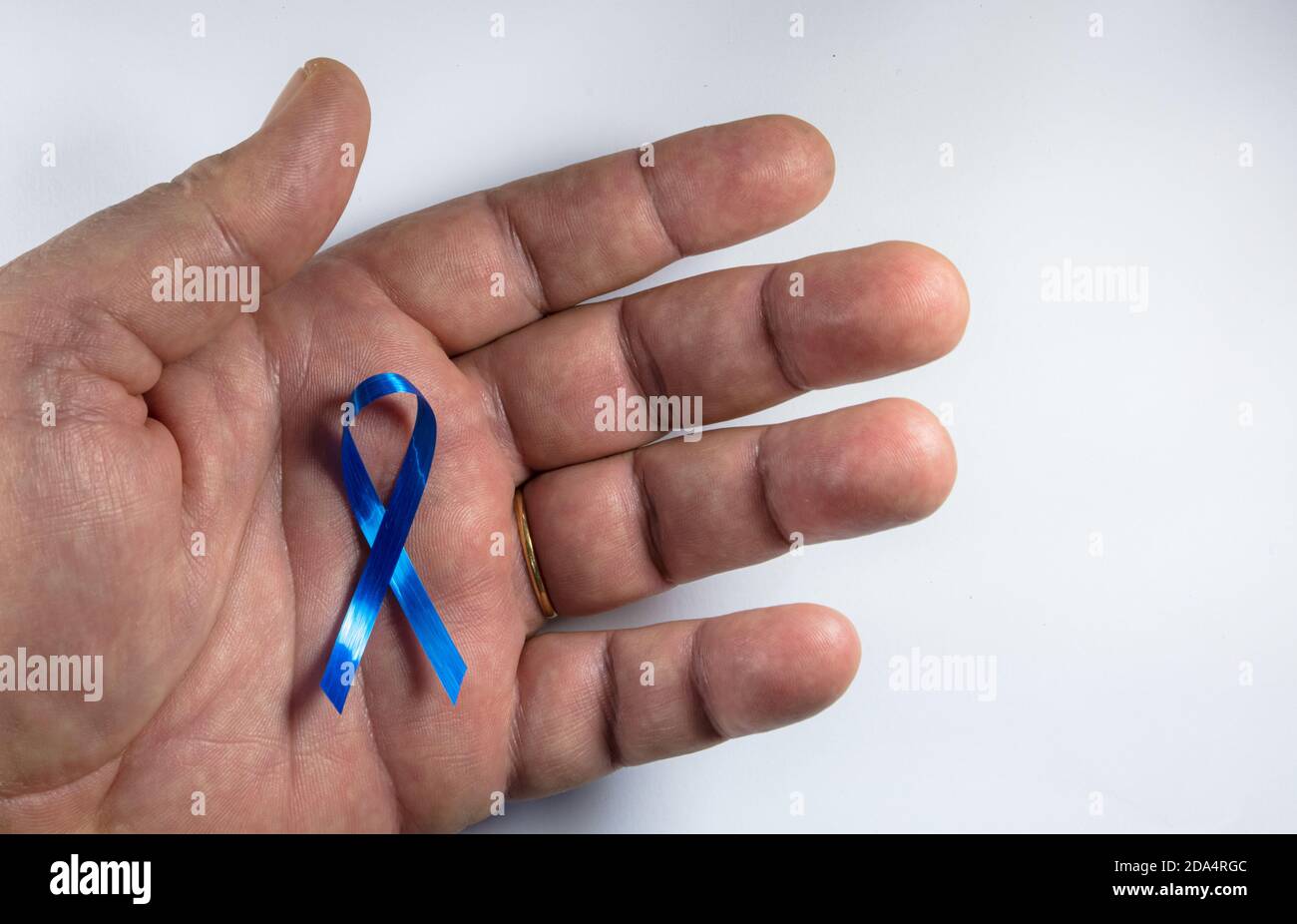 Male palm with a blue ribbon for awareness campaign on male health and ...