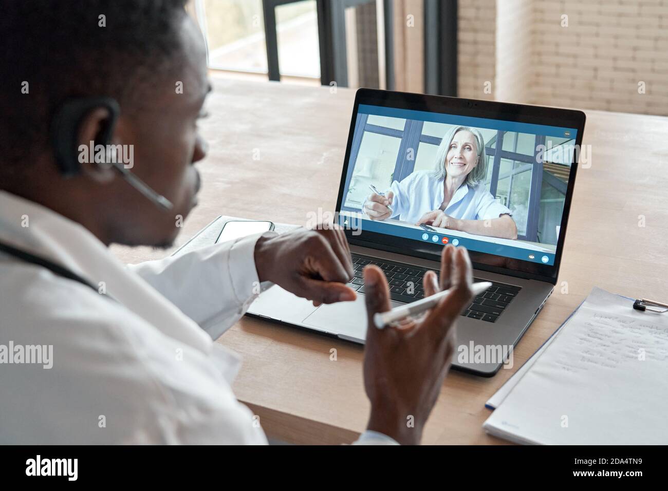Black male doctor consulting senior patient by telemedicine online ...