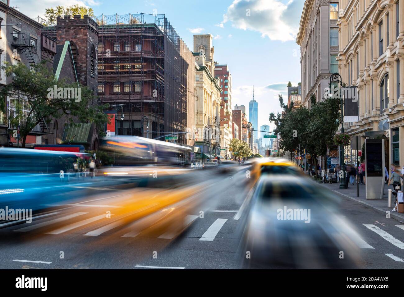 Busy street scene with cars, taxis and buses driving up 6th Avenue ...
