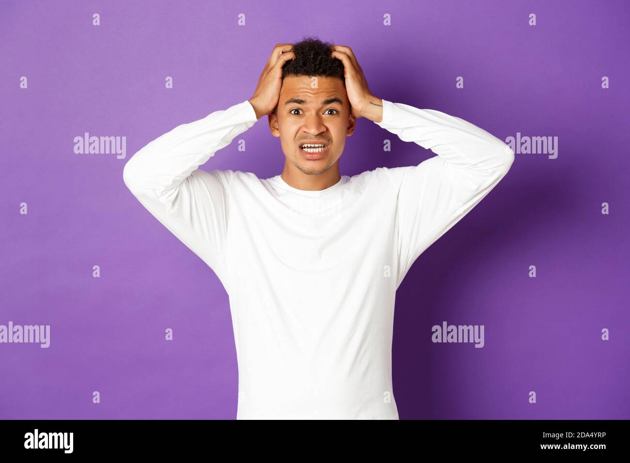 Image of handsome african-american man in panic, holding hands on head ...