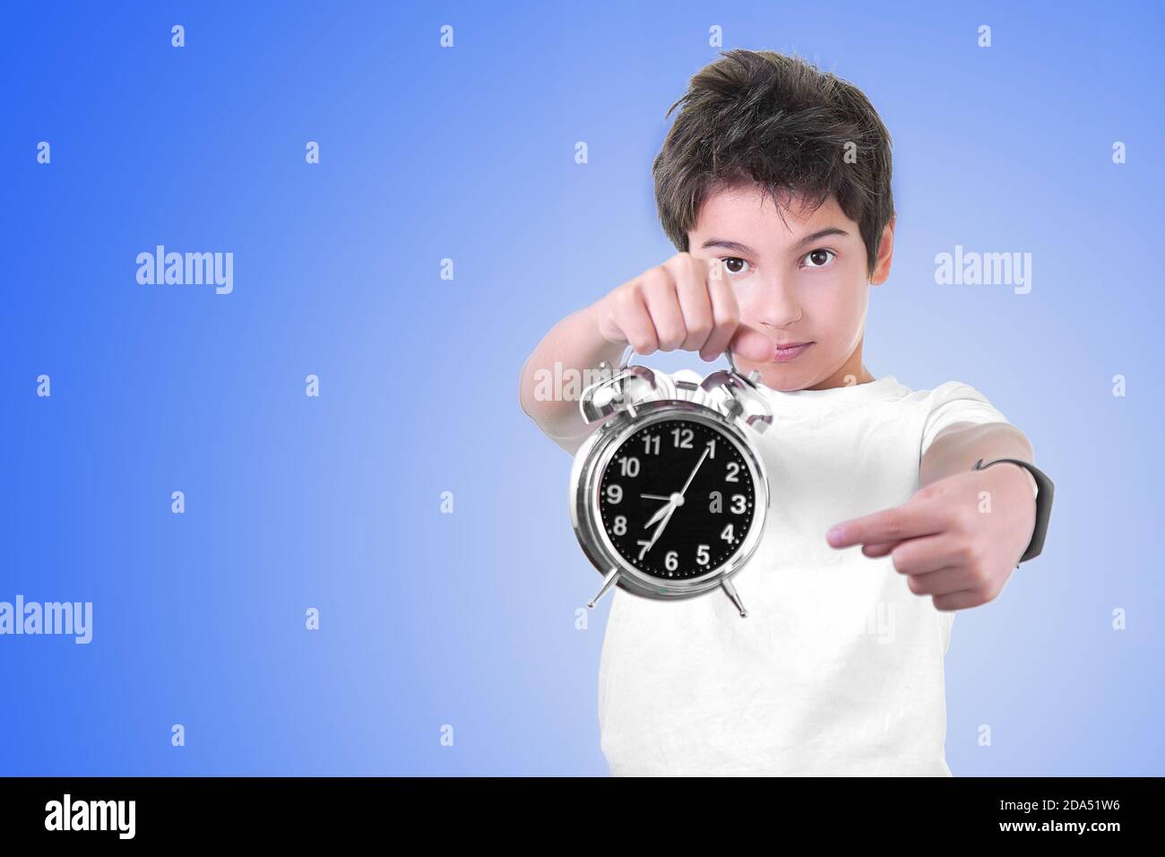 School boy with alarm clock in hands isolated on blue. Time to go Stock ...