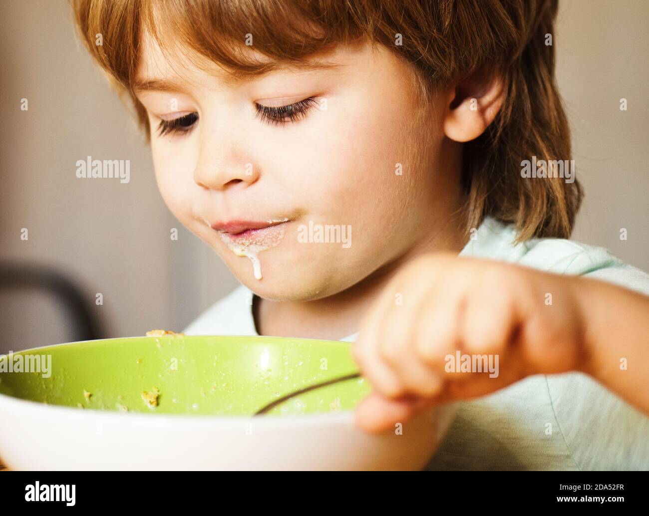 Kid eating. Little boy having breakfast in the kitchen Stock Photo - Alamy