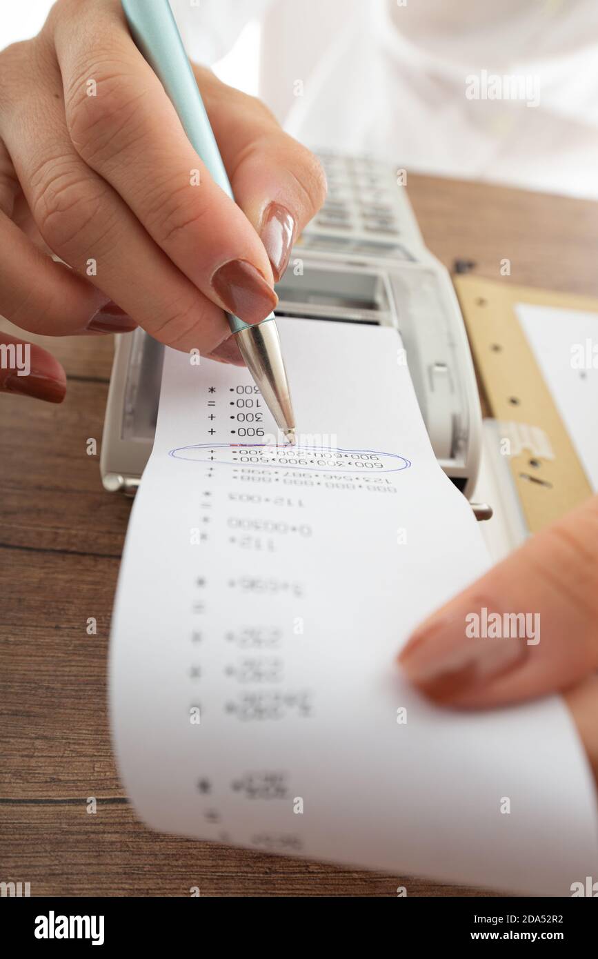 Closeup view of an accountant checking receipt coming out of an adding ...