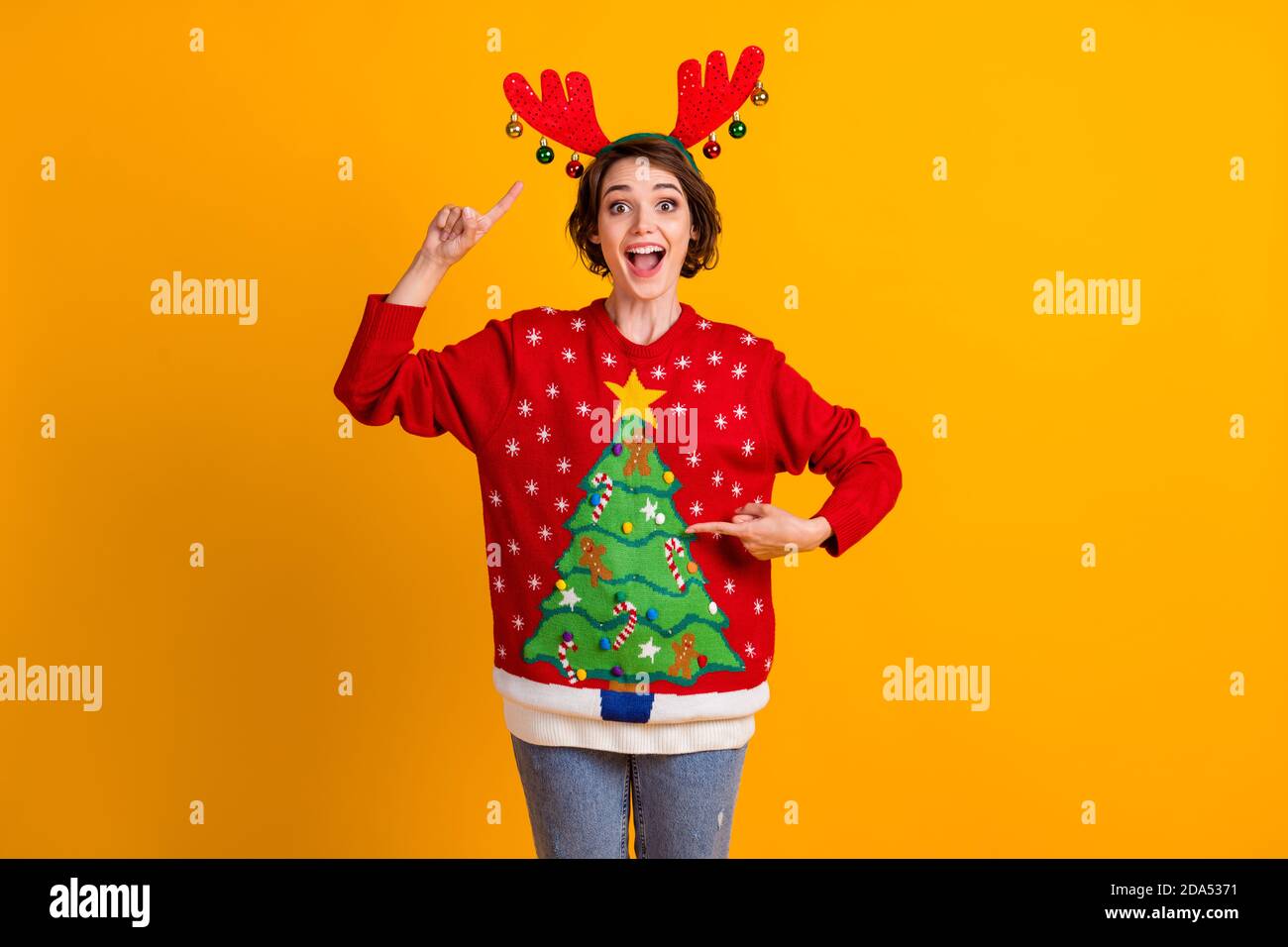 Photo of amazed positive girl point finger deer headband christmas tree ...