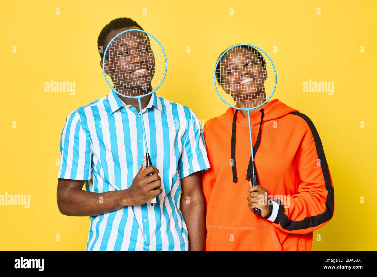 guy and woman of african appearance with badminton rackets in hands ...