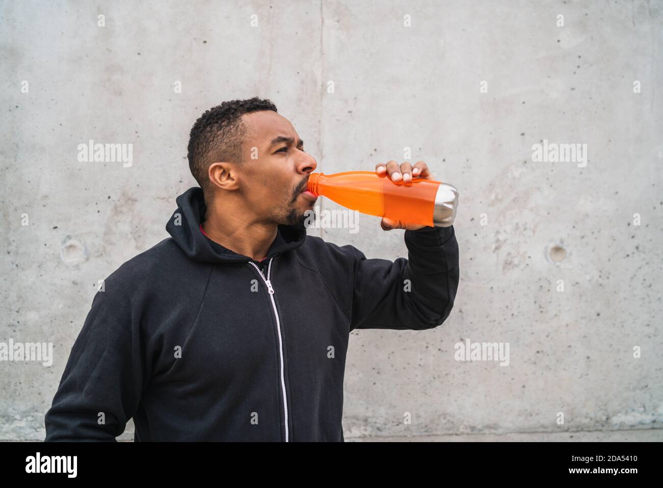 Athletic man drinking something after training Stock Photo - Alamy