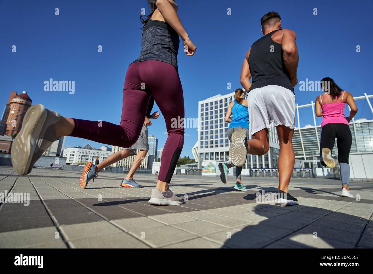 Bottom view of athletes running along paved area in city Stock Photo ...