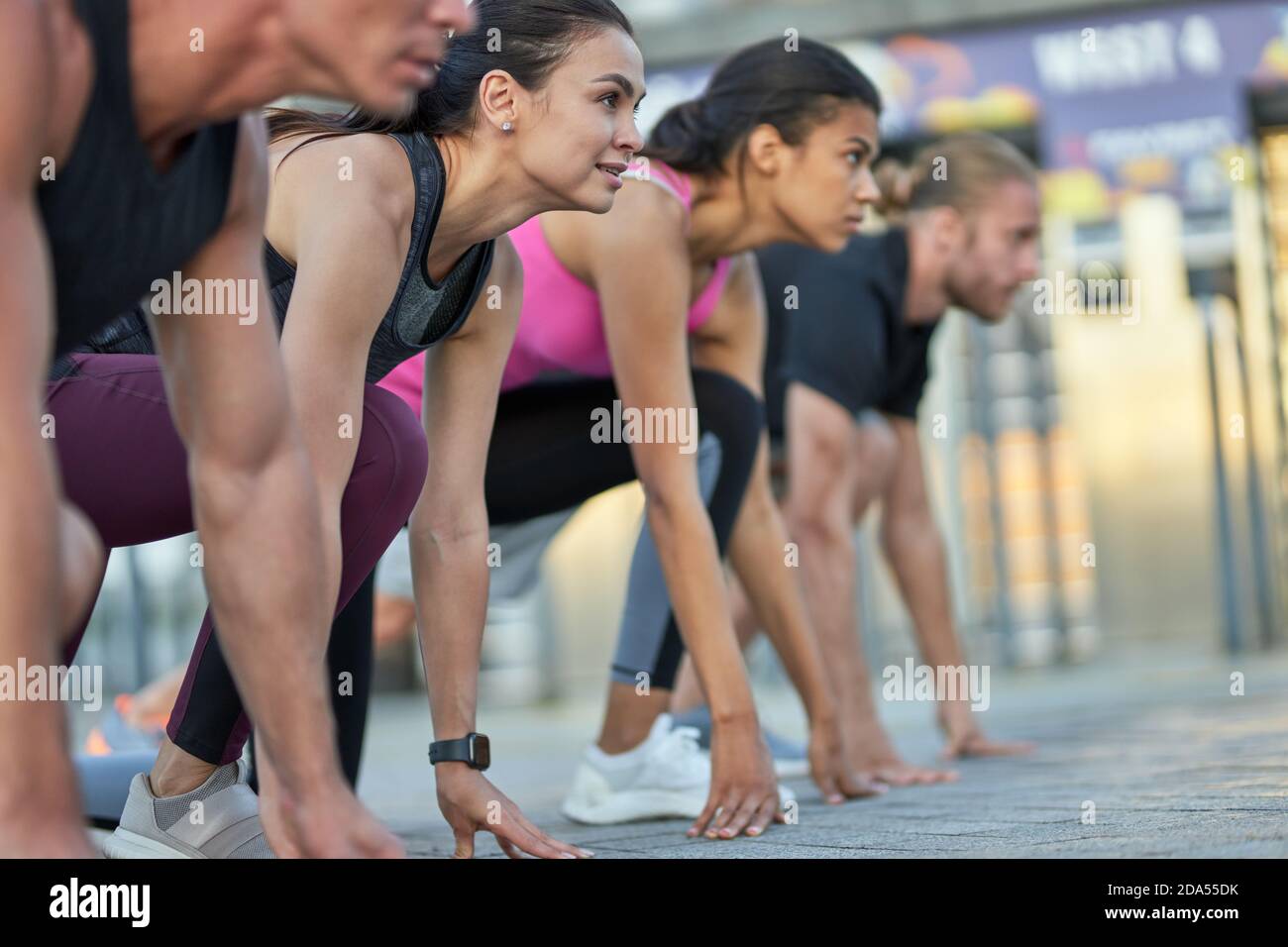 Young multiracial team sitting in low start position for run Stock ...