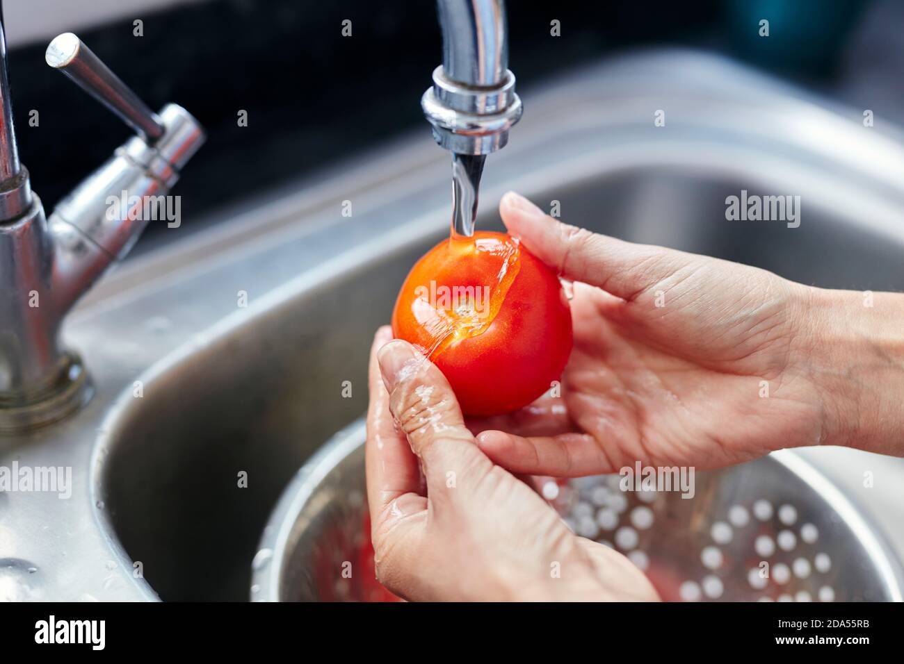 Washing tomato in sink Stock Photo - Alamy