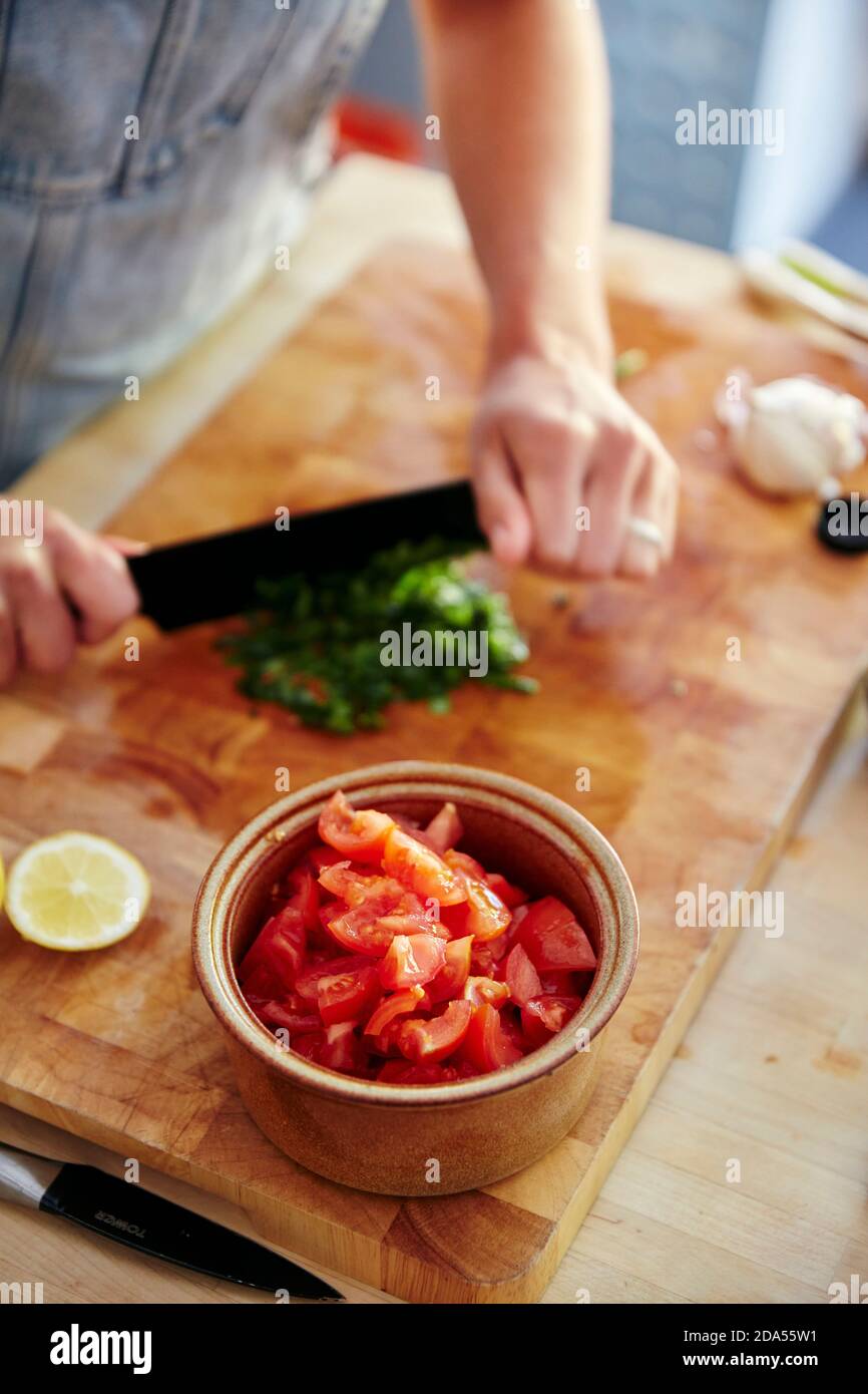 Chopping basil for tomato salad Stock Photo - Alamy