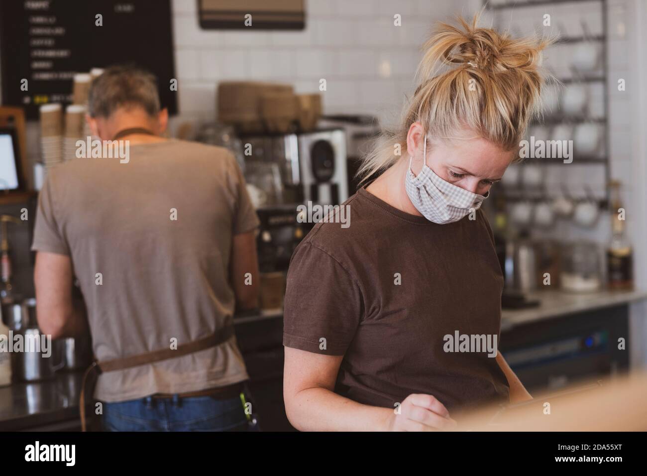 Blond waitress wearing face mask working in a cafe Stock Photo - Alamy