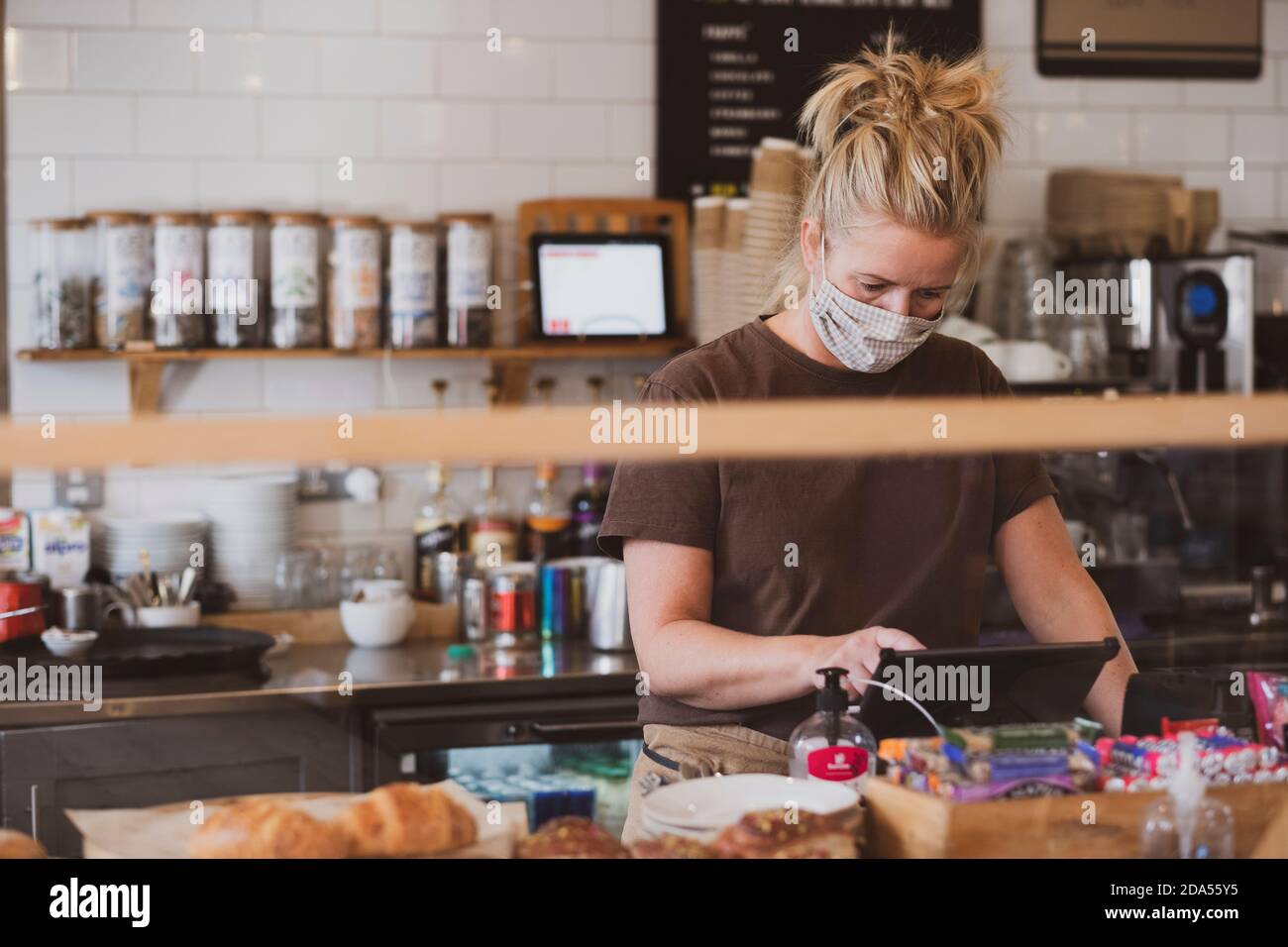 Blond waitress wearing face mask working in a cafe Stock Photo - Alamy