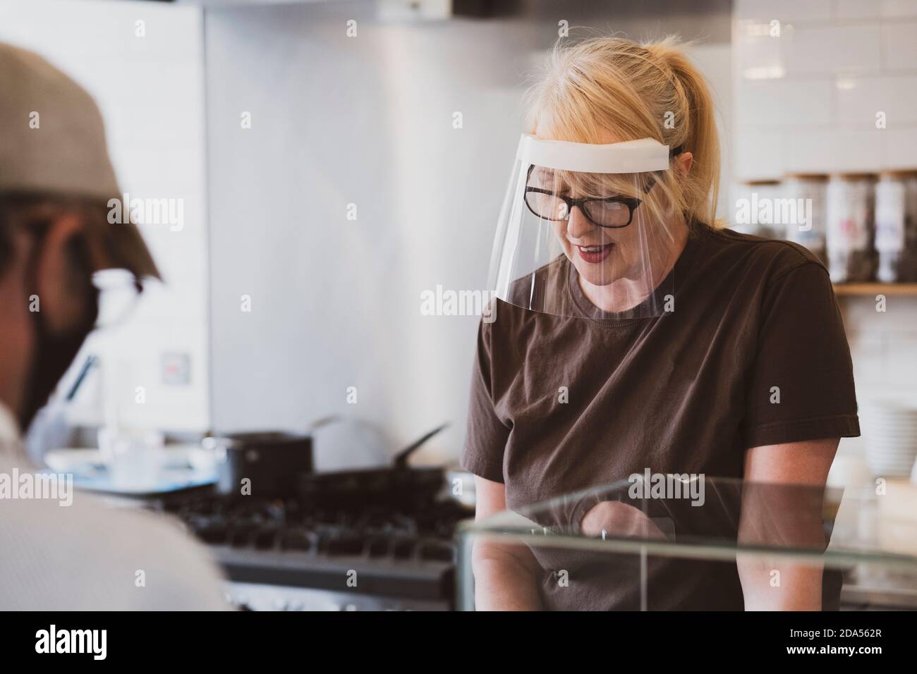 Blond waitress wearing face mask working in a cafe Stock Photo - Alamy