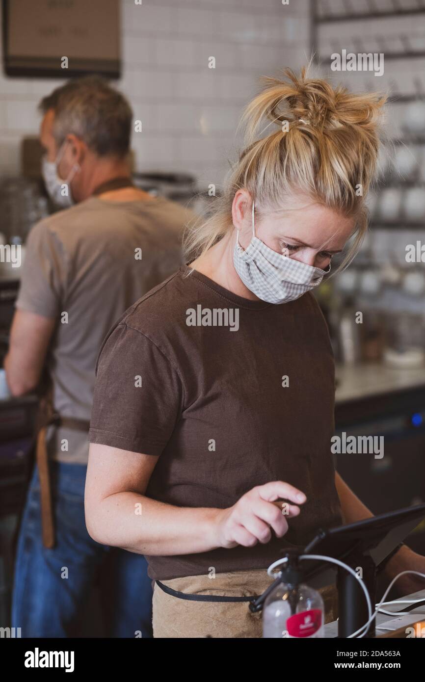 Blond waitress wearing face mask working in a cafe Stock Photo - Alamy