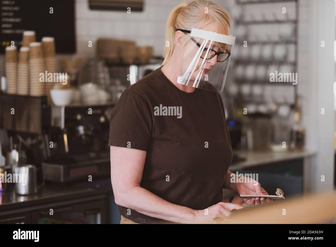 Blond waitress wearing face mask working in a cafe Stock Photo - Alamy