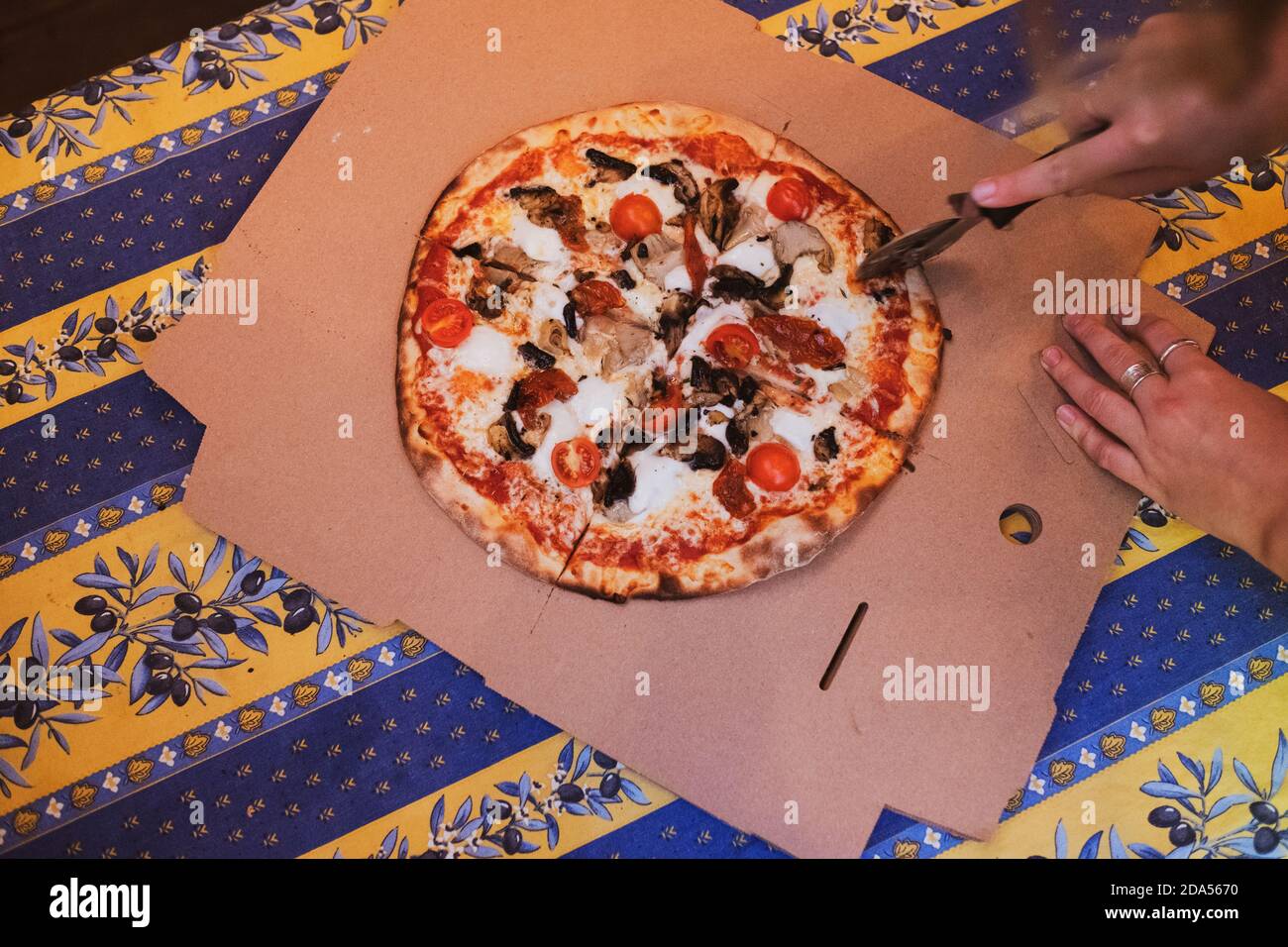 High angle close up of person cutting pizza with a pizza wheel Stock ...