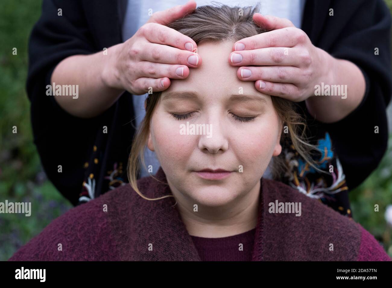 Therapist using both hands touching the top of a client's head Stock Photo - Alamy