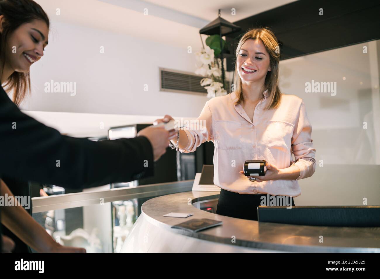 Guest makes card payment at check-in at reception Stock Photo - Alamy