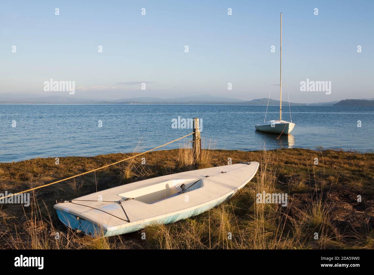 Small boats on the coast, beached on sand and moored in water Stock ...