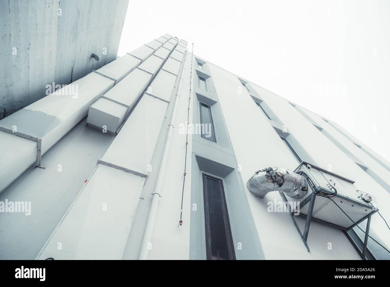 Wide-angle bottom view of a white building facade with three vertical ...