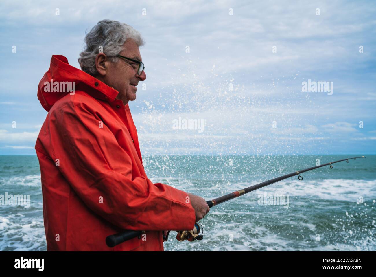 Old man fishing in the sea Stock Photo - Alamy