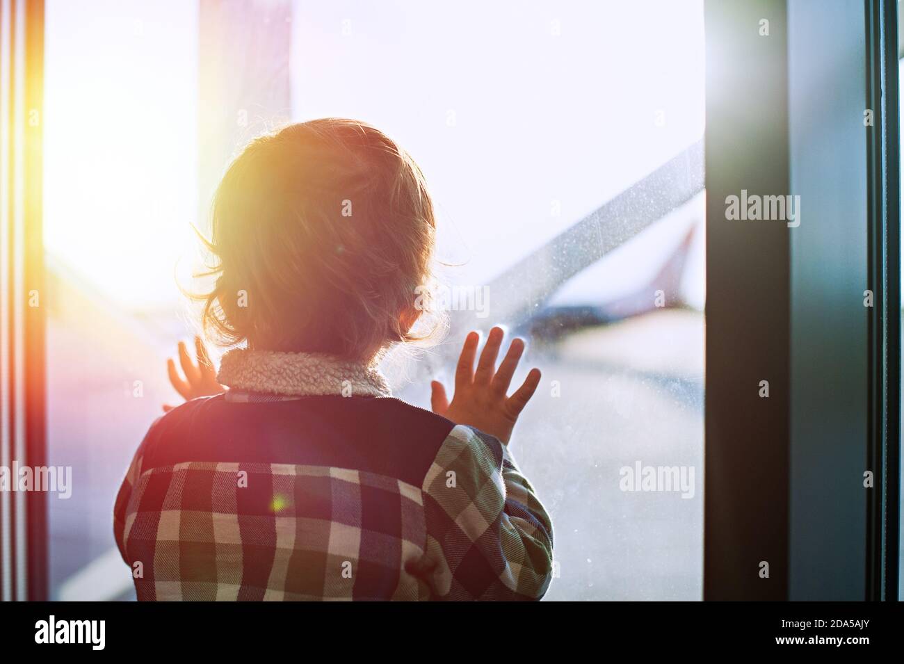 Boy looks out the window at the airport Stock Photo - Alamy