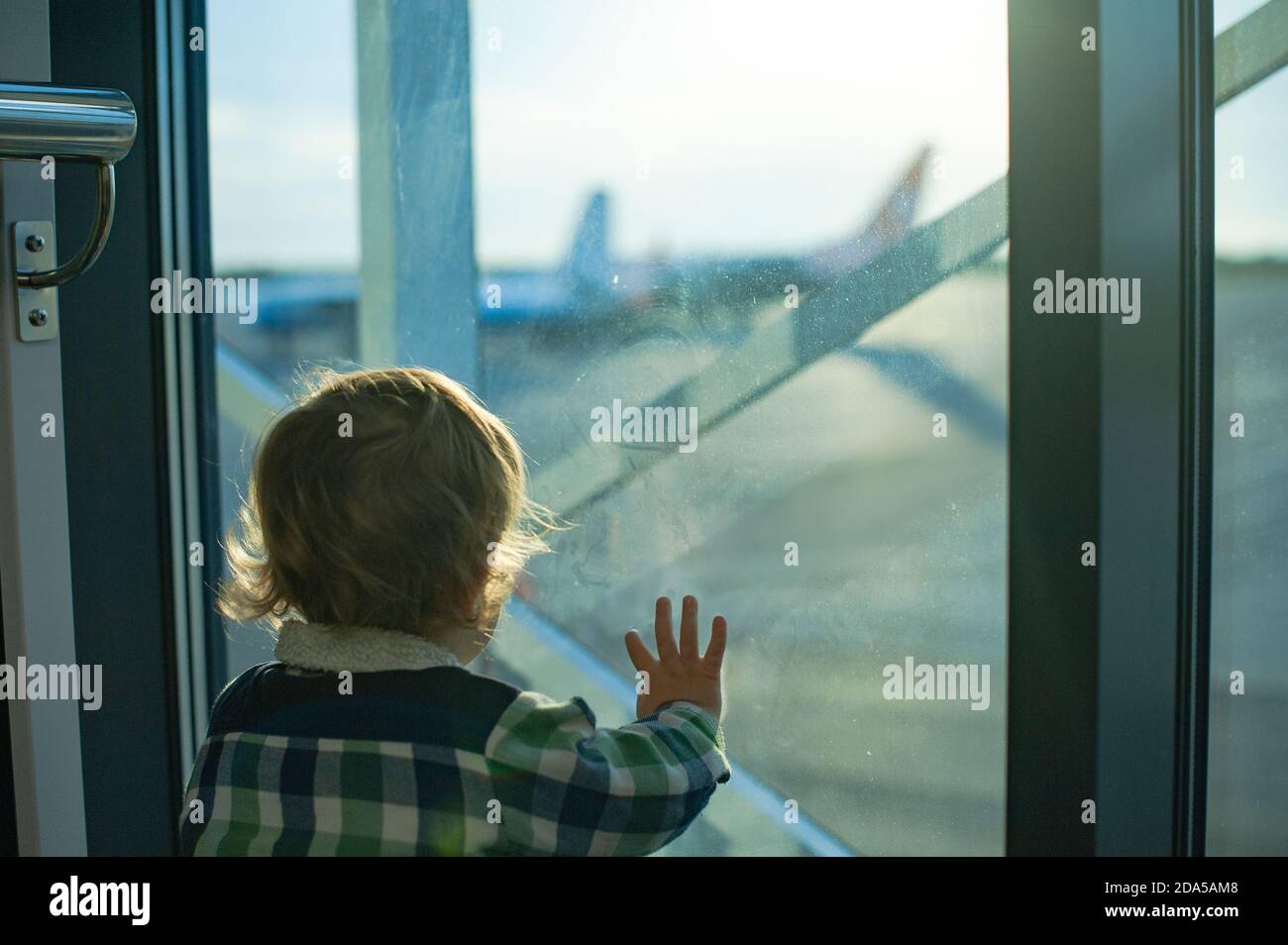 Boy looks out the window at the airport Stock Photo - Alamy