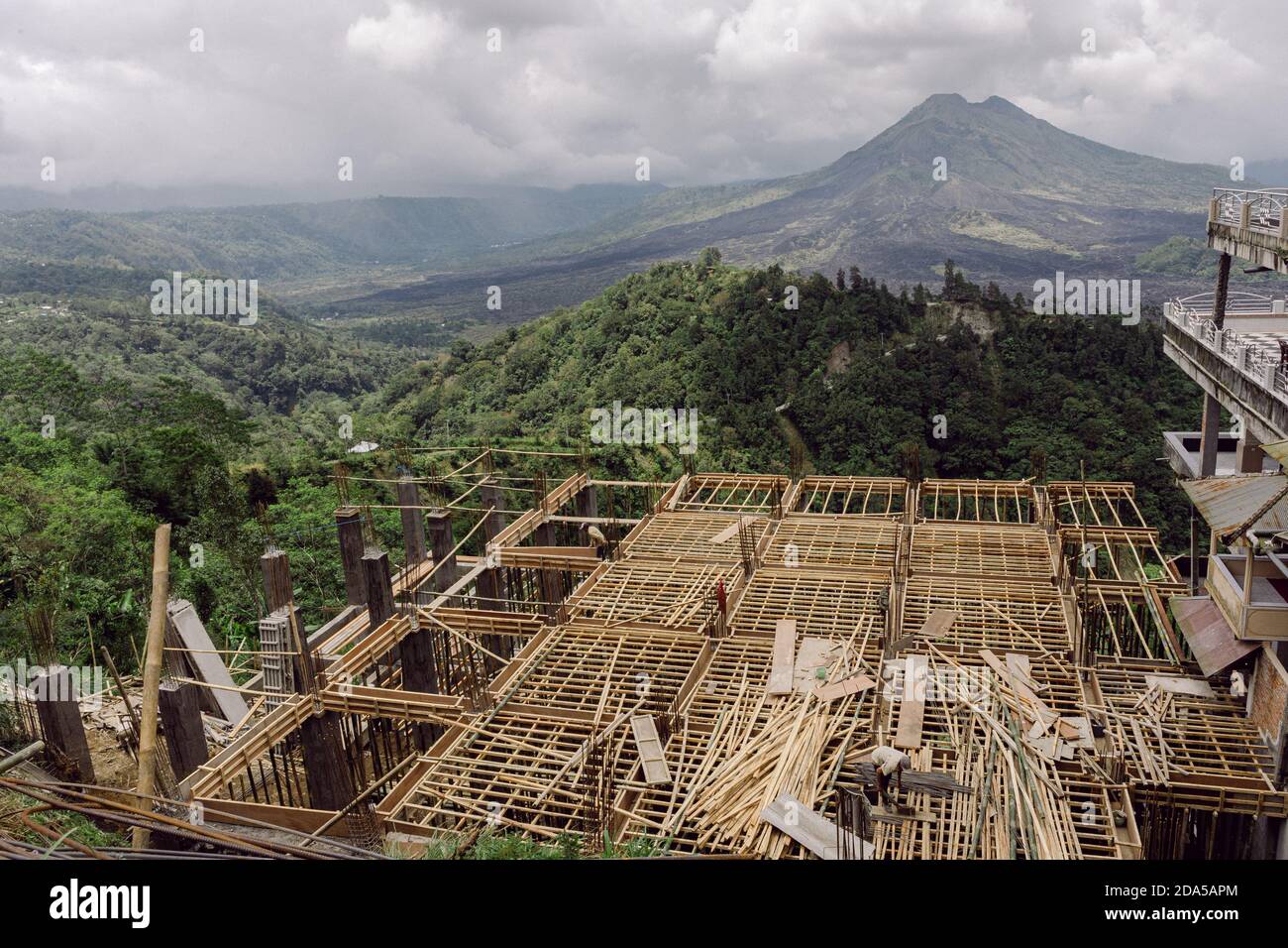 Construction site in Bali, building a wooden house with a volcano in ...