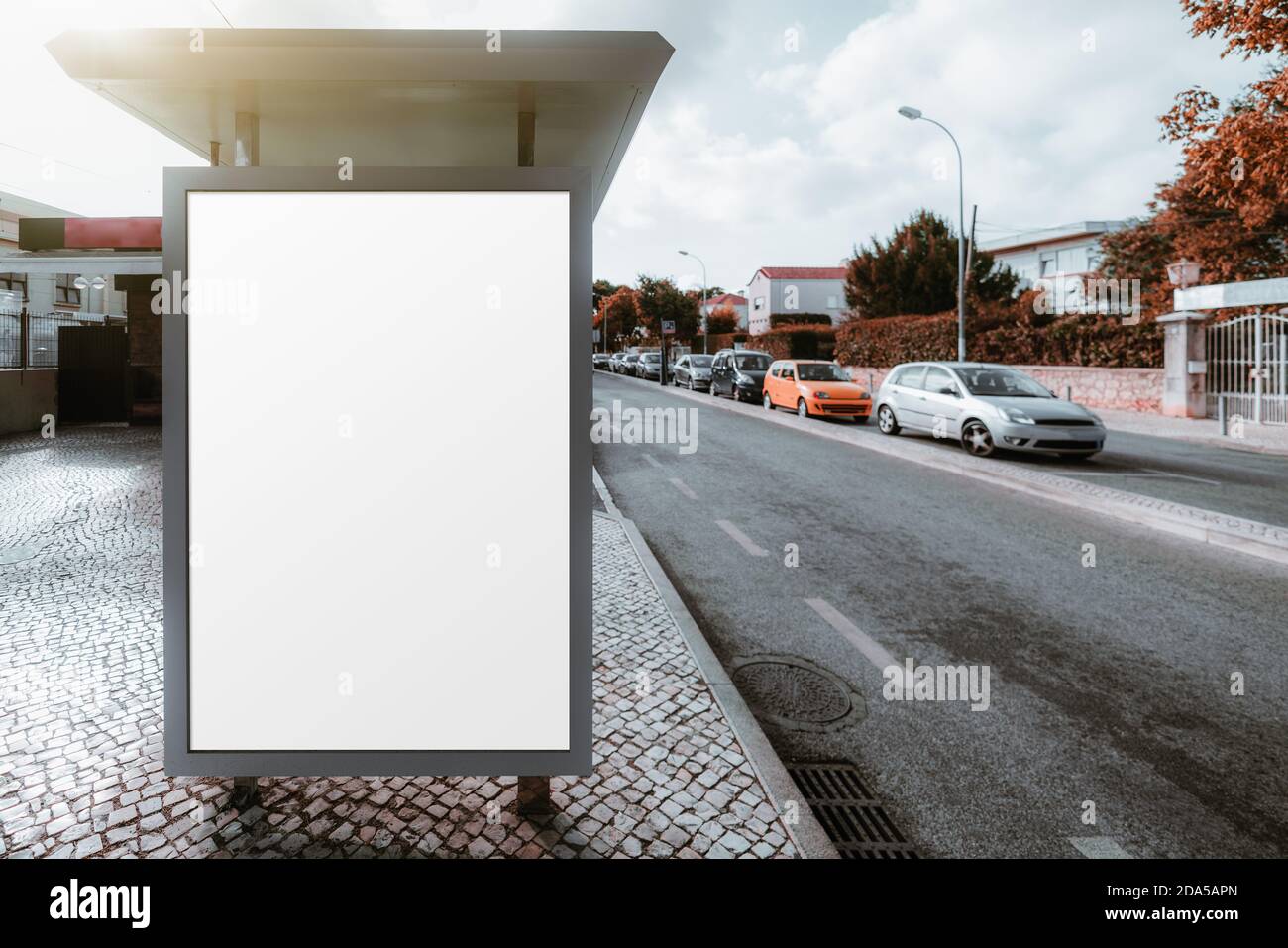 A bus stop near the road with a mockup of a blank advert poster on it ...