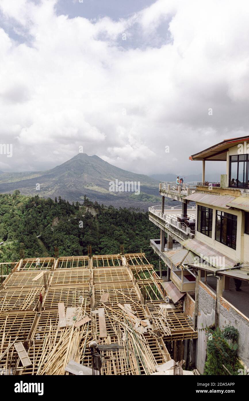 Construction site in Bali, building a wooden house with a volcano in ...