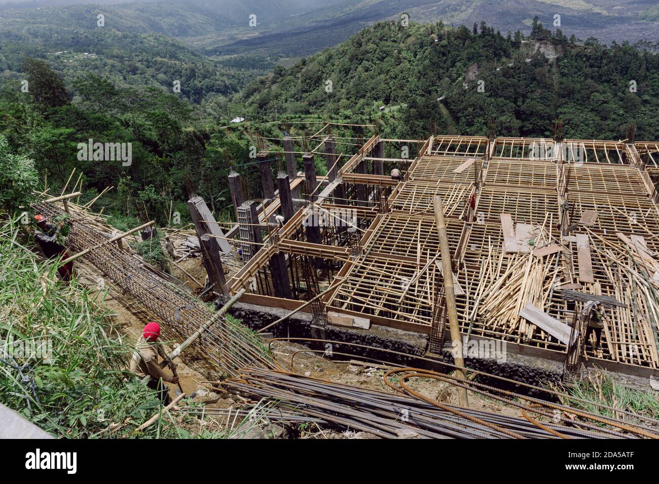 Construction site in Bali, building a wooden house with a volcano in ...