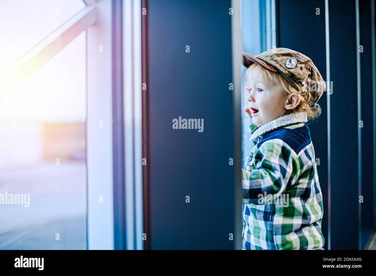 Boy looks out the window at the airport Stock Photo - Alamy