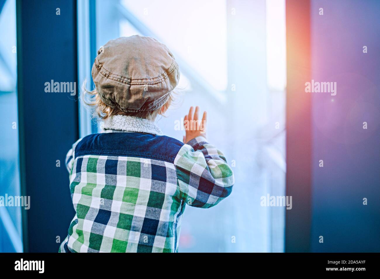 Boy looks out the window at the airport Stock Photo - Alamy
