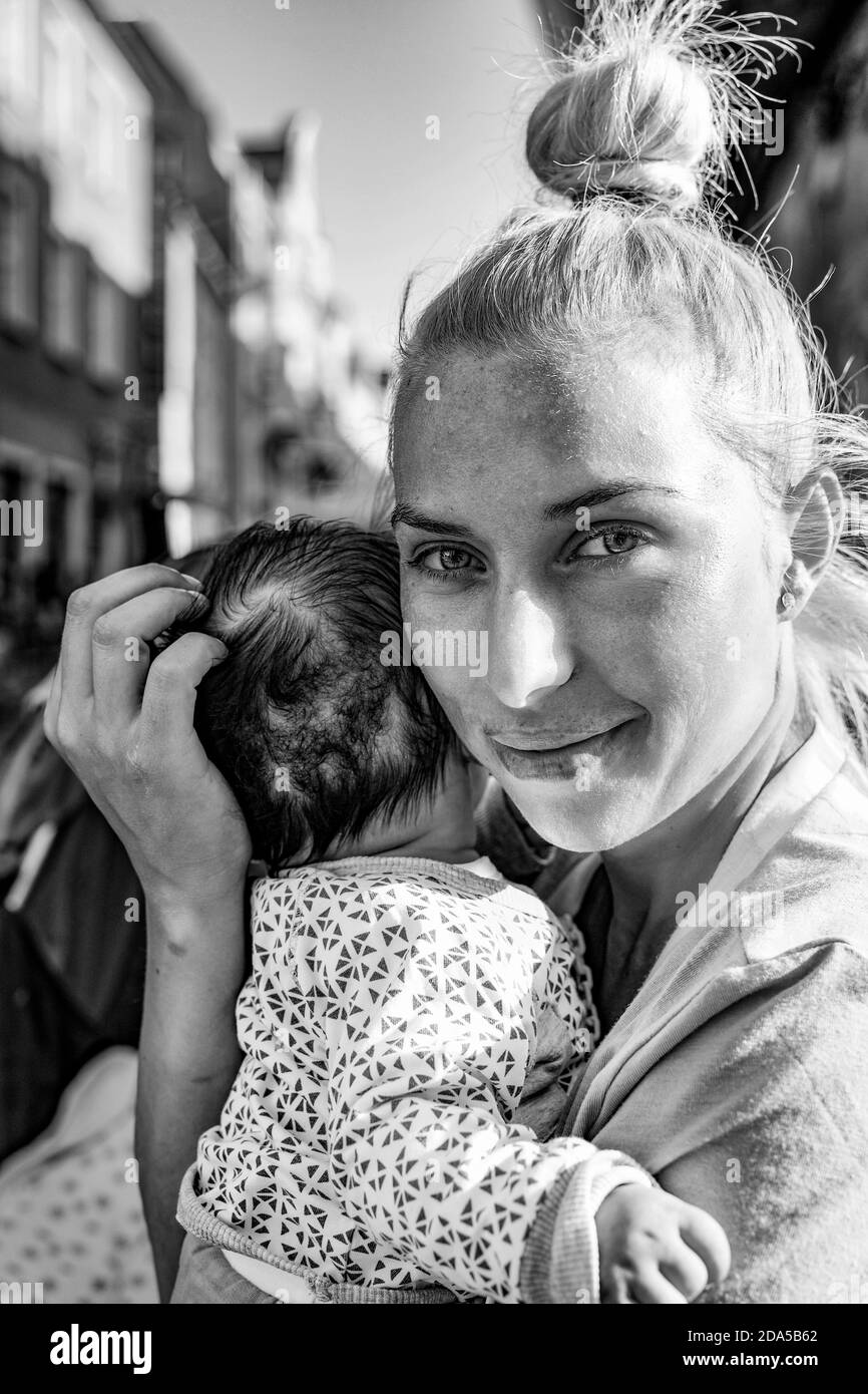 Loving mother - romanian girl hugging her child. Old town.Poznan ...