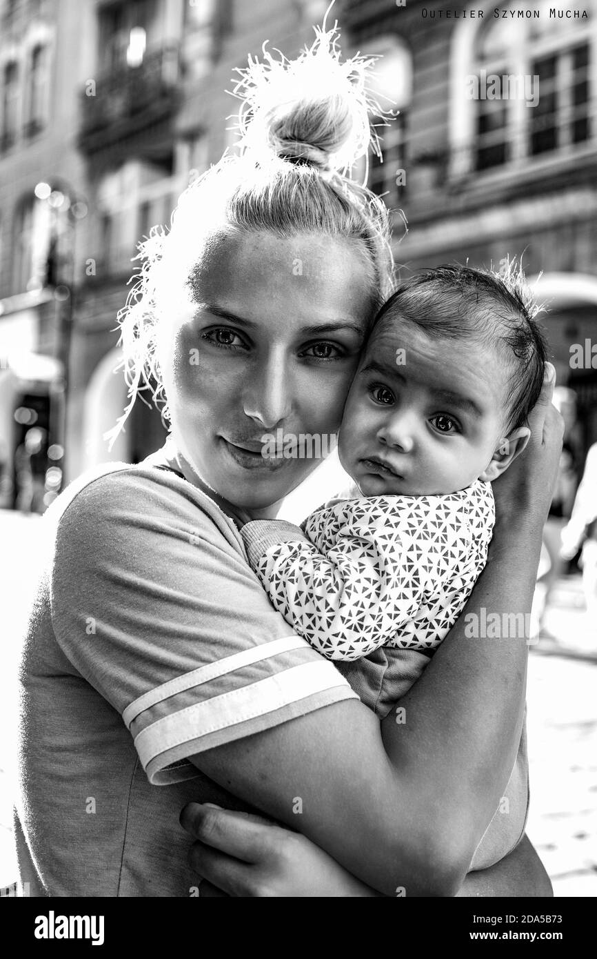 Loving mother - romanian girl hugging her child. Old town.Poznan ...