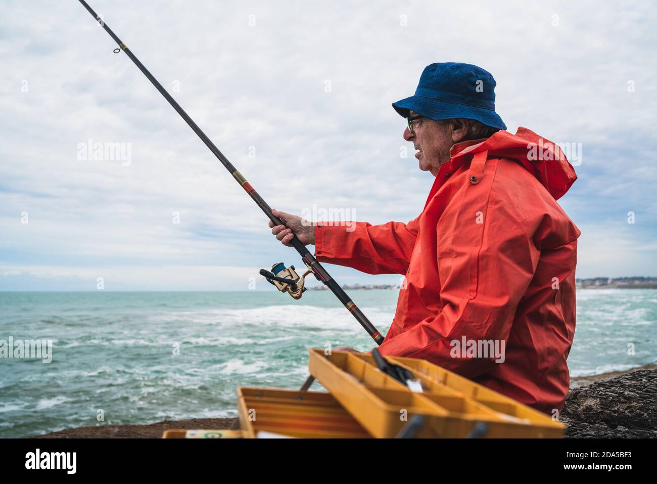 Old man fishing in the sea Stock Photo - Alamy