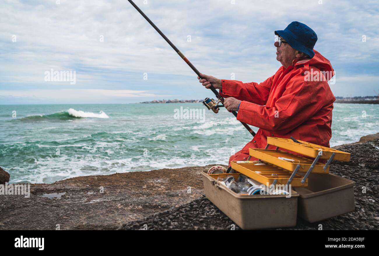 Old man fishing in the sea Stock Photo - Alamy