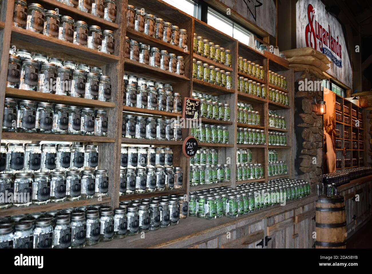 Multiple Rustic barn wood shelves display moonshine in jars at ...