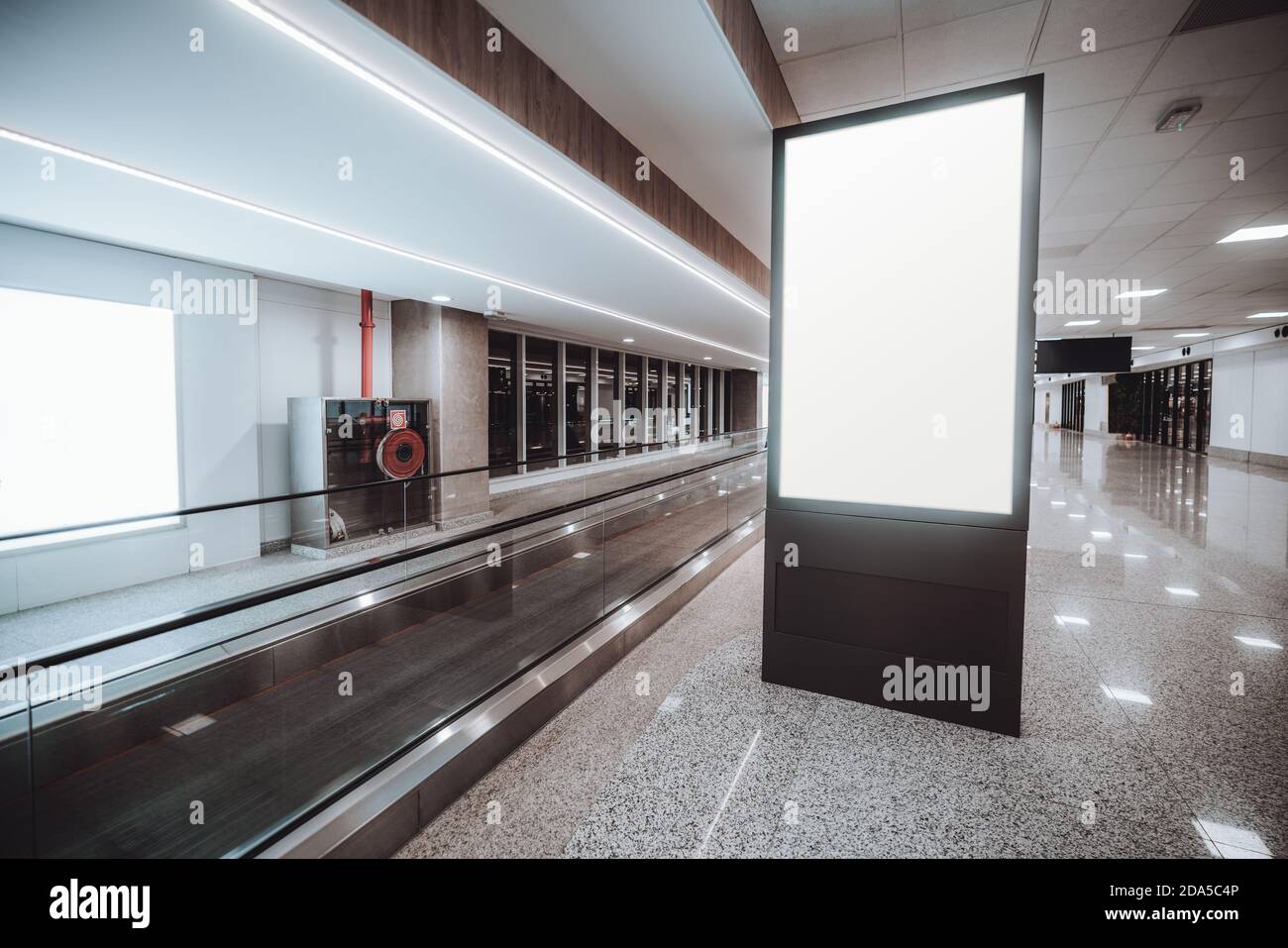 A blank glowing vertical ver ad billboard placeholder mock-up near a ...