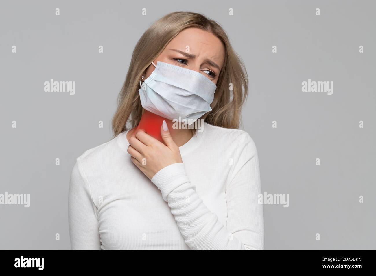 Studio portrait of unhealthy woman in medical face mask scratching her ...