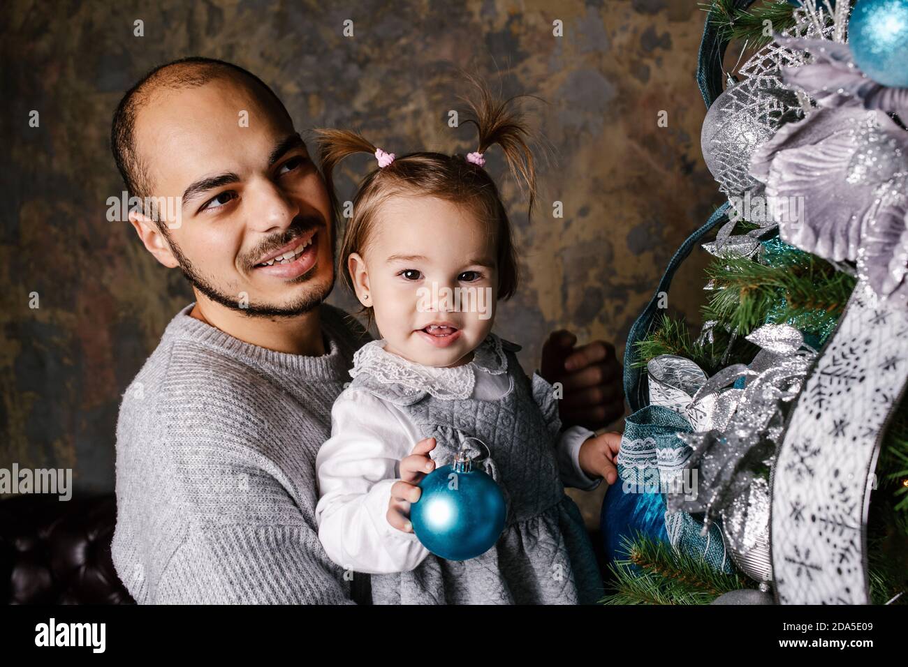 Happy Father and Daughter decorate the Christmas tree. Happy little ...