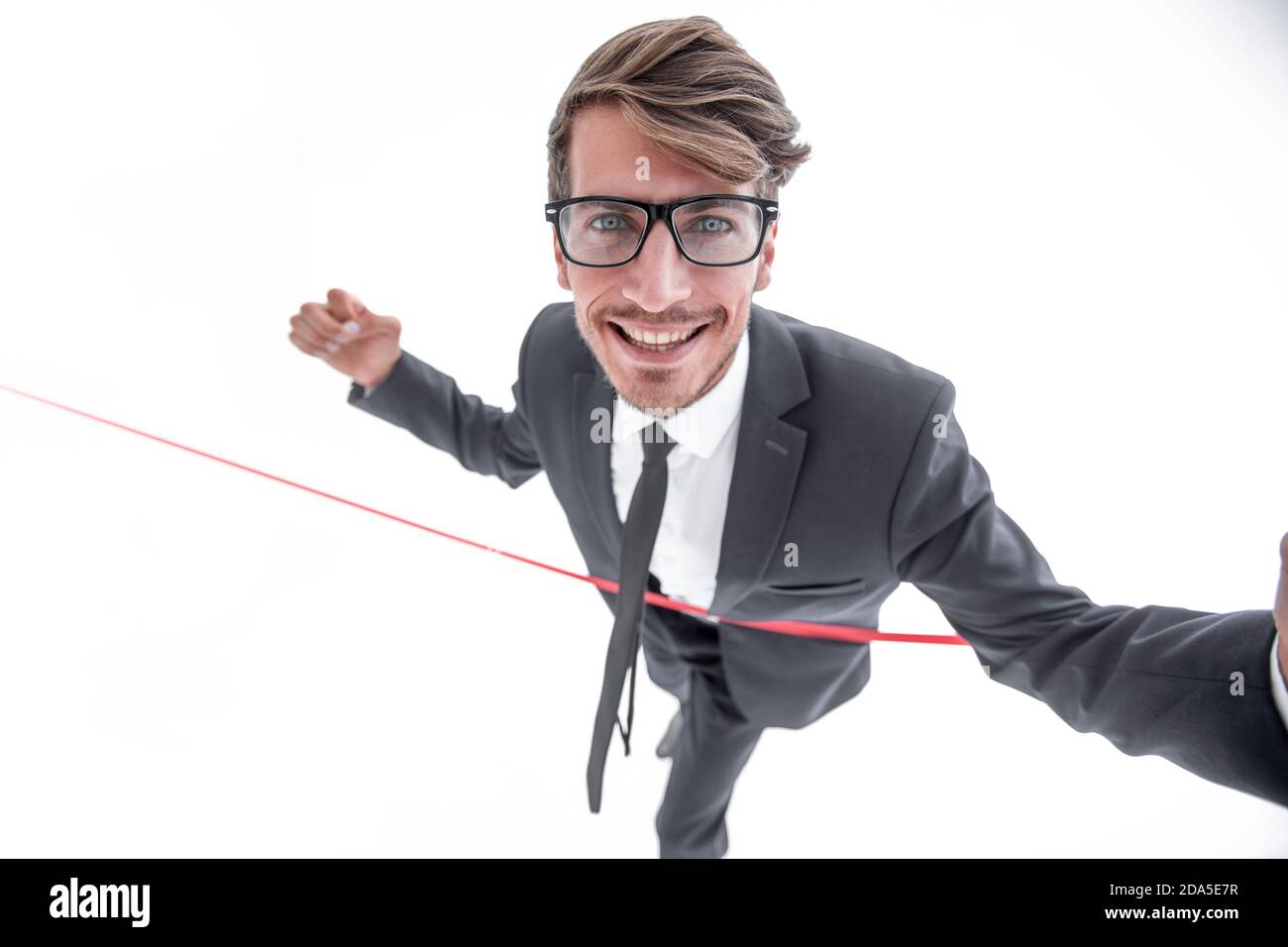 Cheerful businessman crossing red finish line Stock Photo - Alamy