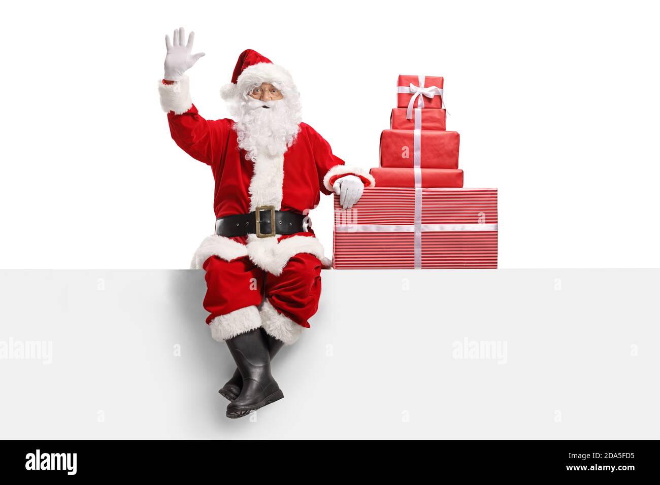 Full length portrait of a santa claus with presents sitting on a white ...